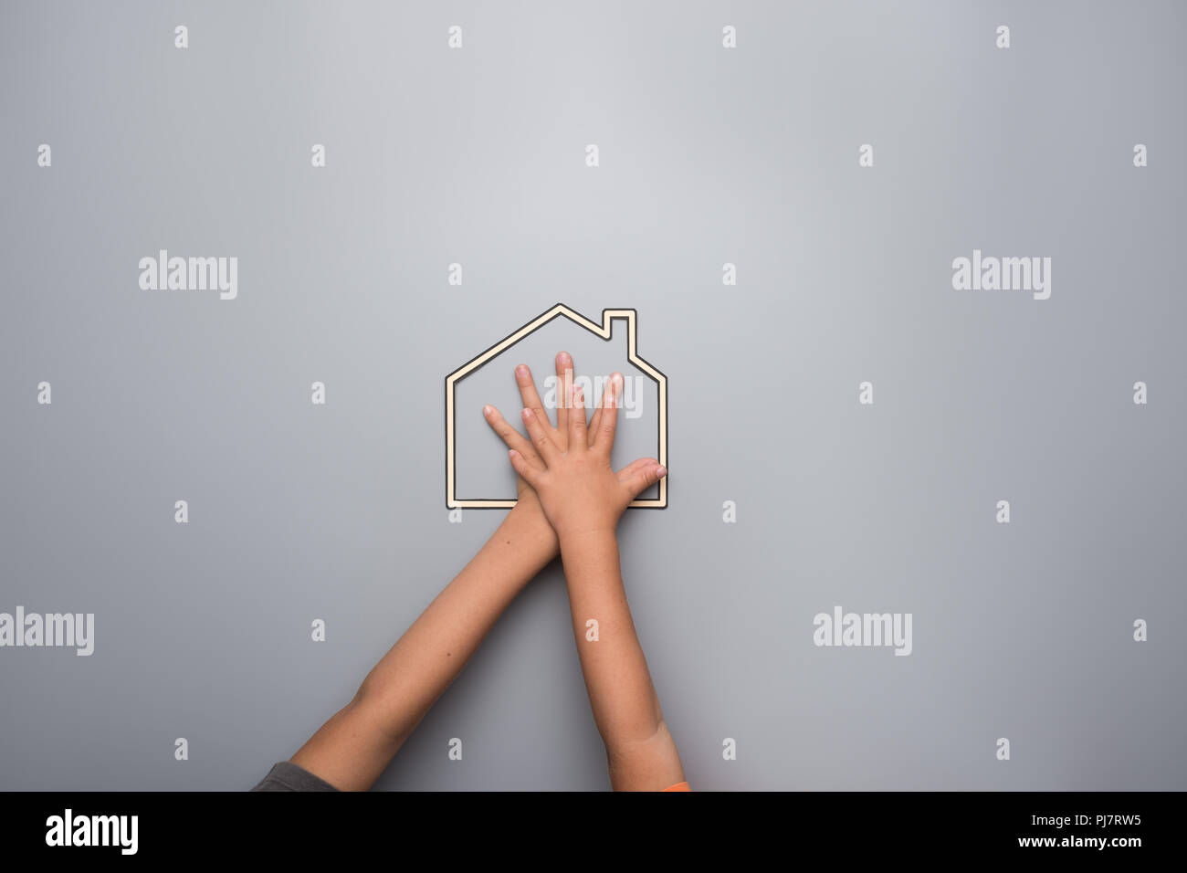Hands of two children inside the frame of a house indicating love for ...