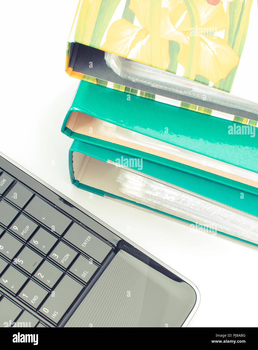 Laptop computer with colored file folders lying on white desk Stock ...