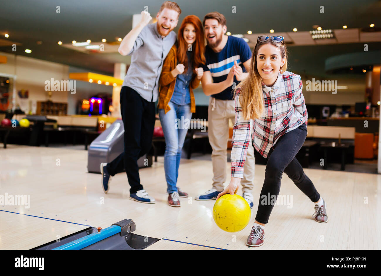 Cheerful friends bowling together Stock Photo - Alamy