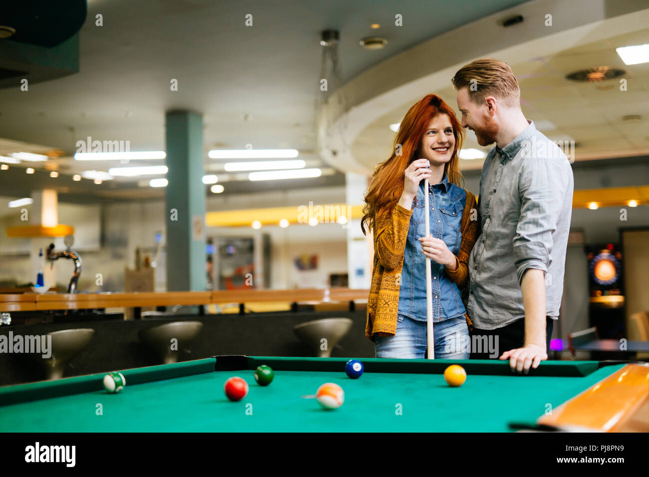 Happy couple playing snooker Stock Photo - Alamy