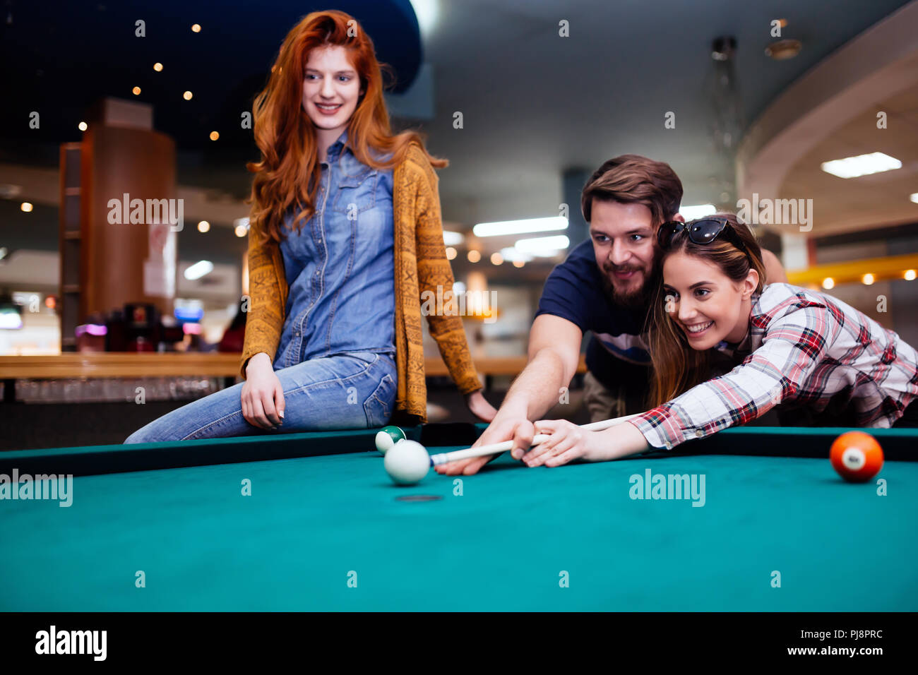 Happy friends enjoying playing pool Stock Photo - Alamy