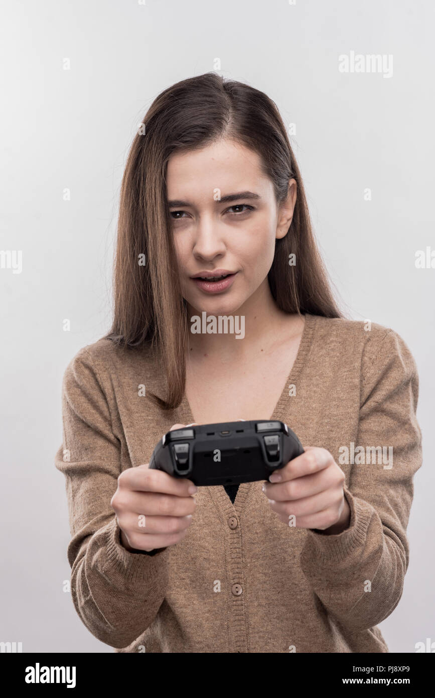 Dark-eyed beautiful woman feeling serious while playing video game ...