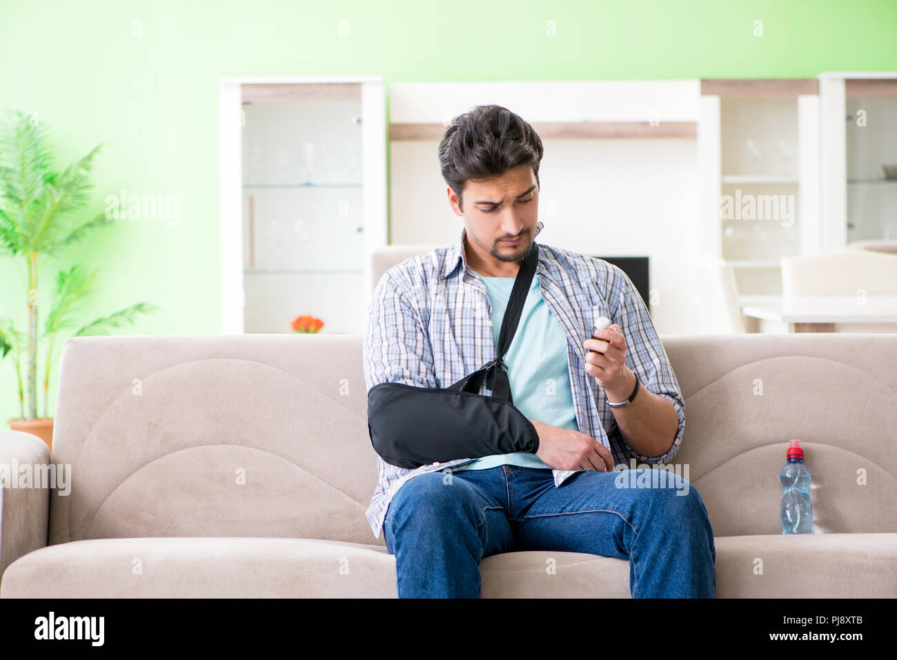 Young student man with hand injury sitting on the sofa Stock Photo - Alamy