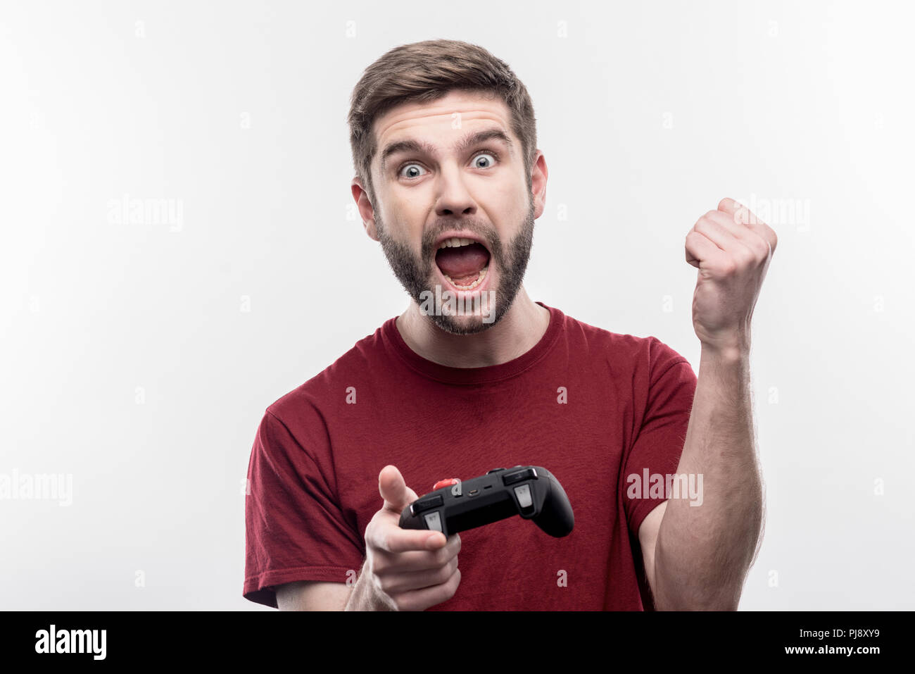 Emotional blue-eyed man feeling happy while playing video games Stock ...