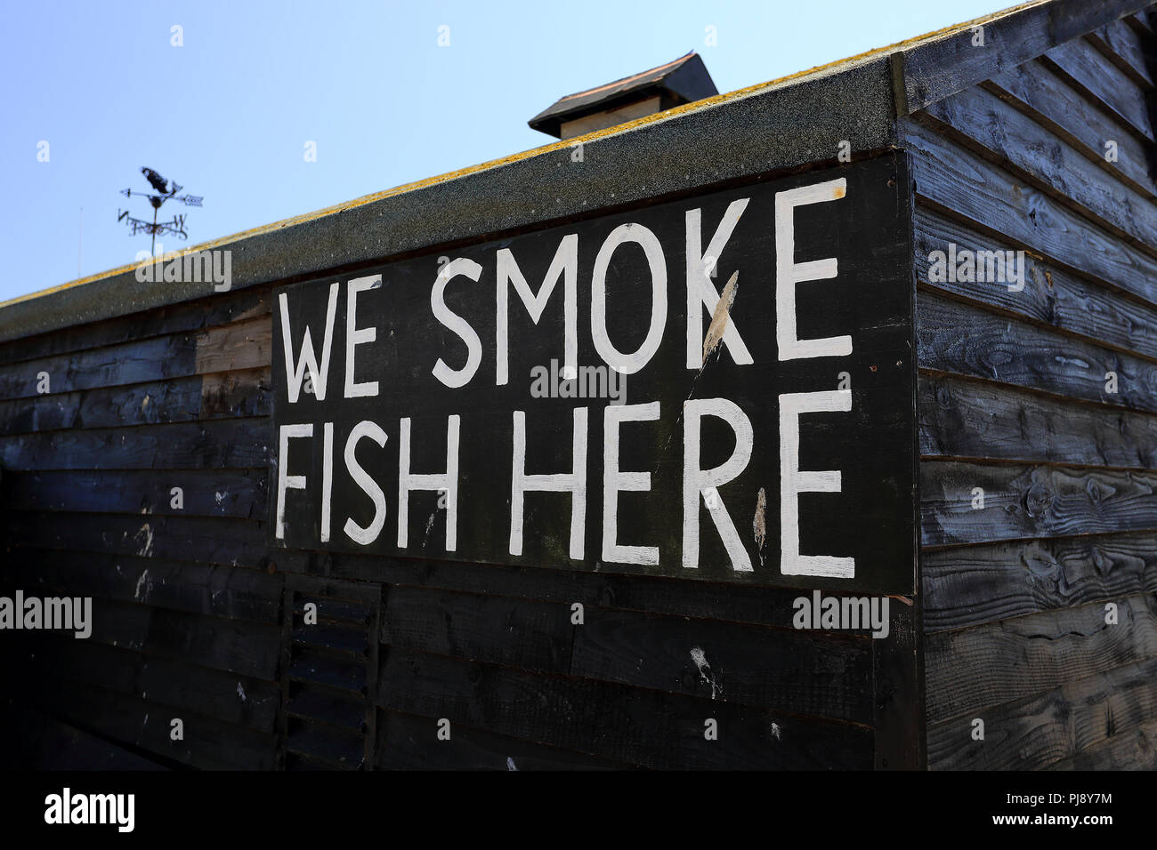 An information sign "We Smoke Fish Here', on the side of a black ...