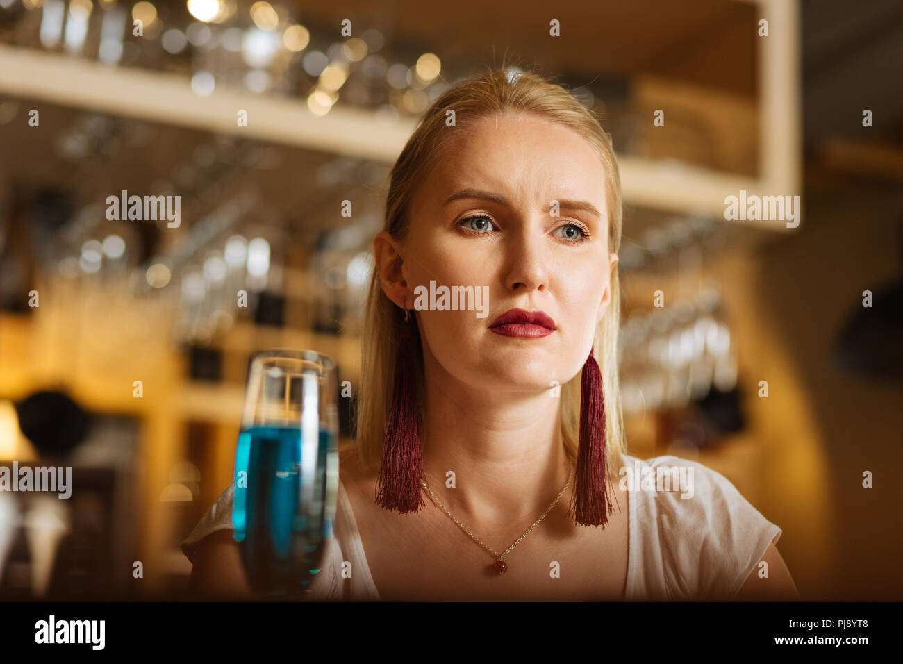 Sad gloomy young woman drinking alcohol alone Stock Photo - Alamy