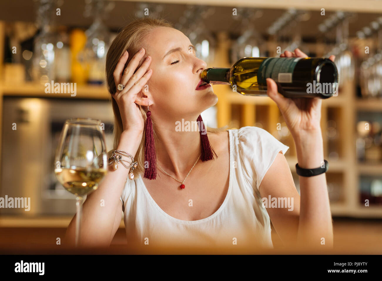 Cheerless young woman suffering from alcohol addiction Stock Photo - Alamy