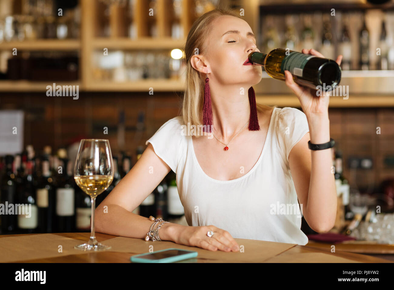 Nice young woman drinking lots of wine Stock Photo - Alamy