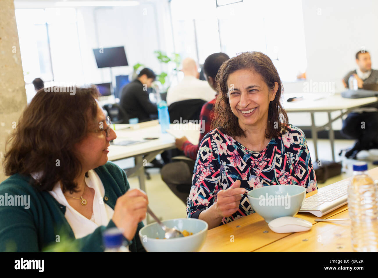 Woman eating at office desk hi-res stock photography and images - Alamy