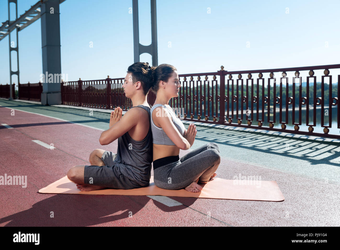 Calm woman and man meditating back to back Stock Photo - Alamy