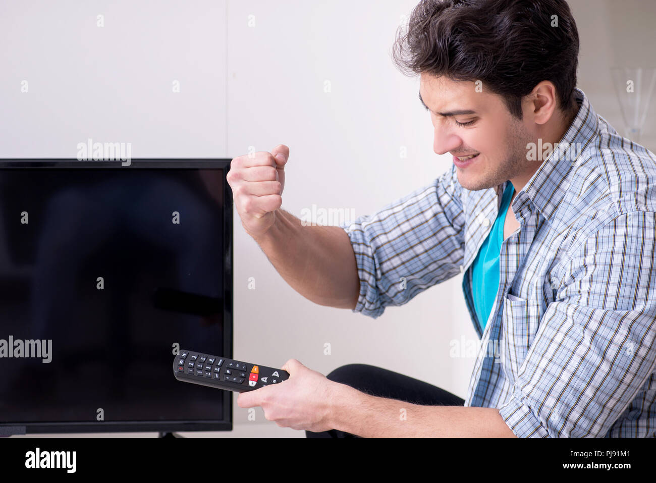 Man trying to fix broken tv Stock Photo - Alamy