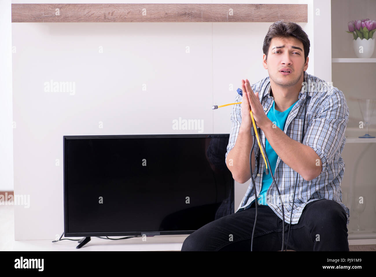 Man trying to fix broken tv Stock Photo - Alamy