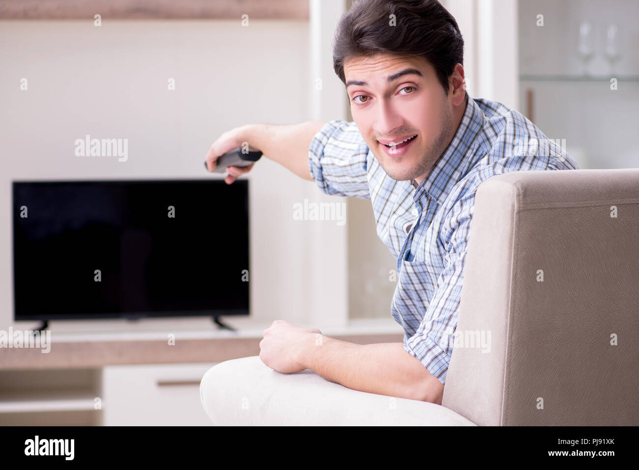 Young man watching tv at home Stock Photo - Alamy