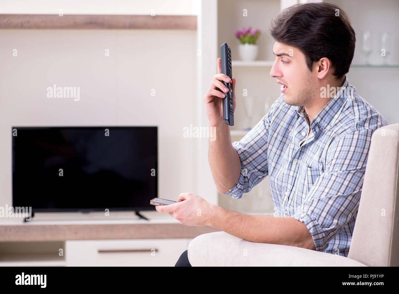 Young man watching tv at home Stock Photo - Alamy