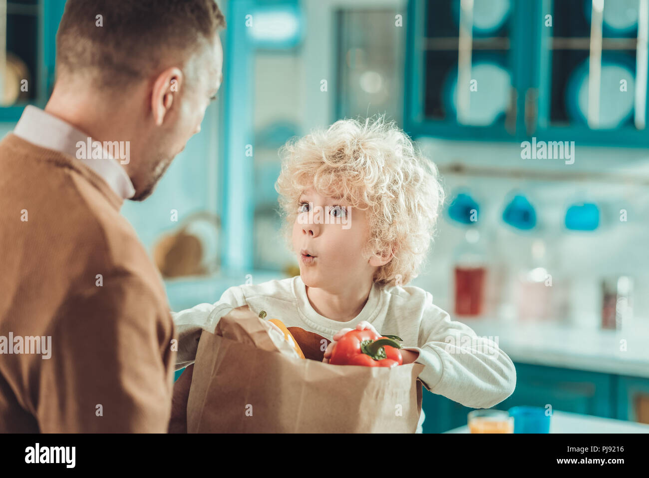 Shocked child looking at father with curiosity Stock Photo - Alamy