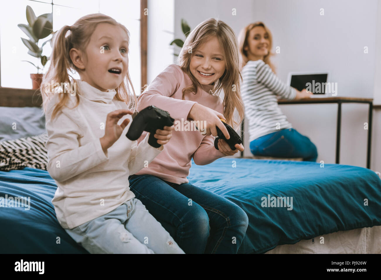 Positive joyful girls holding game consoles Stock Photo - Alamy