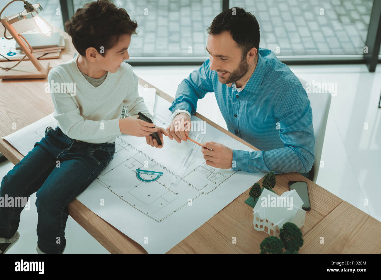 Positive happy boy showing a picture to his father Stock Photo - Alamy