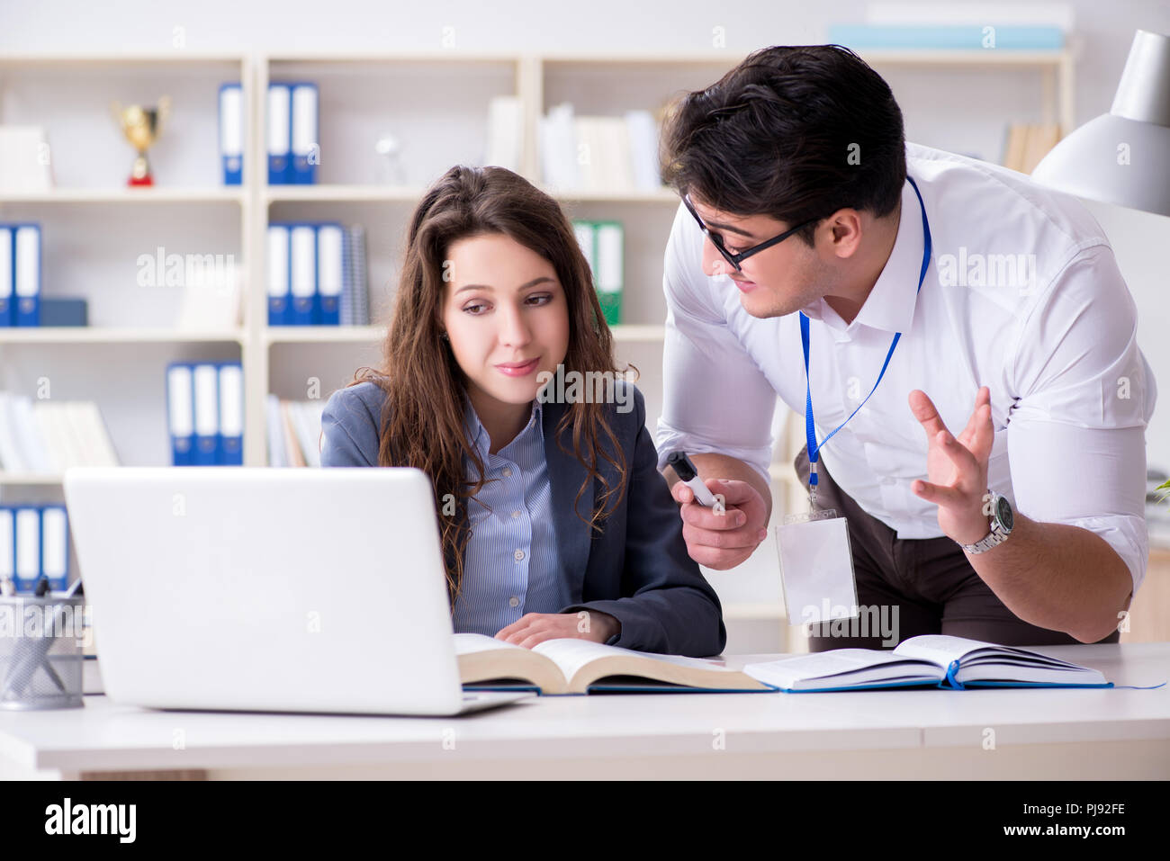 Teacher explaining to student at lecture Stock Photo - Alamy