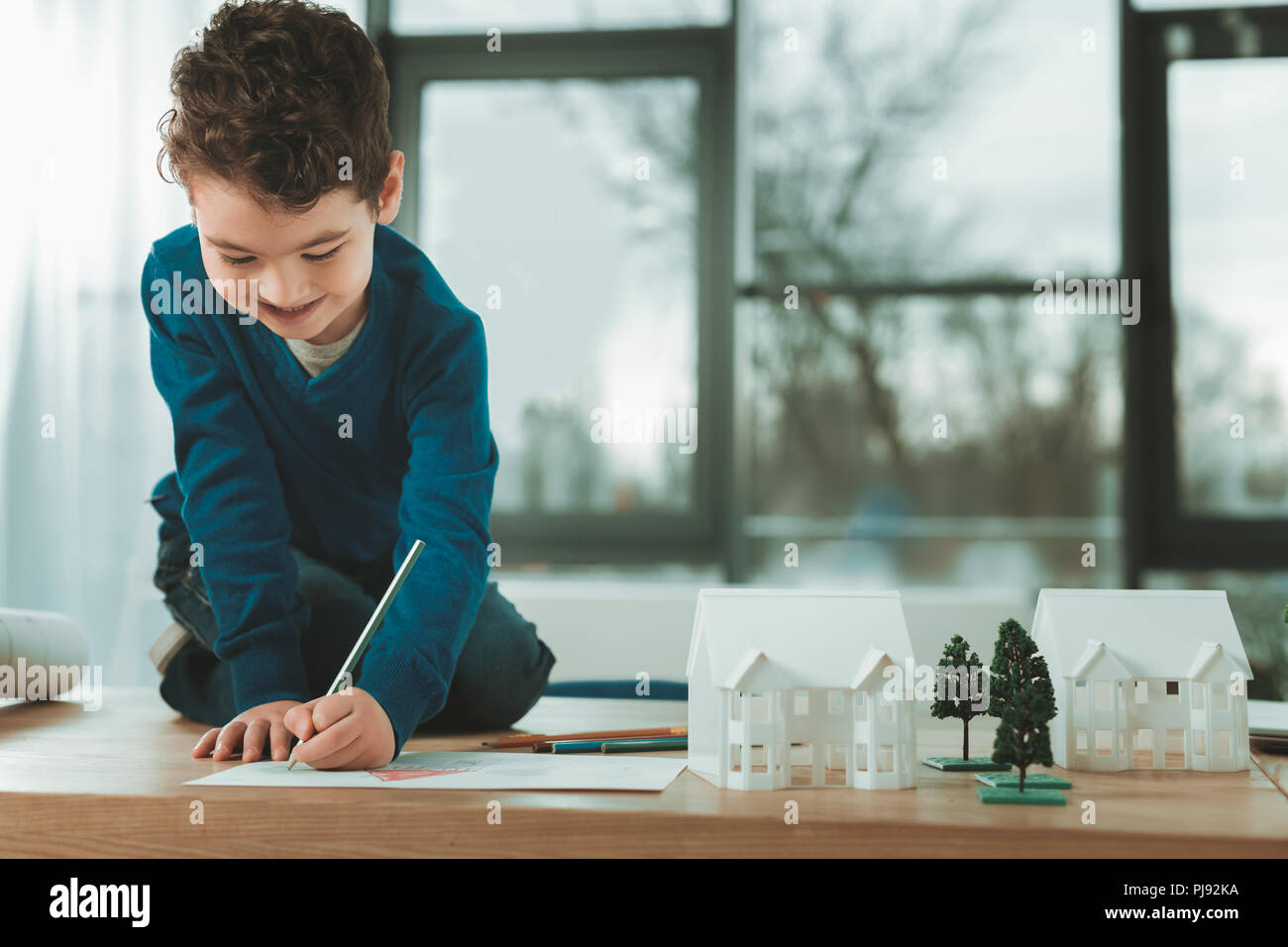 Joyful happy boy drawing Stock Photo - Alamy
