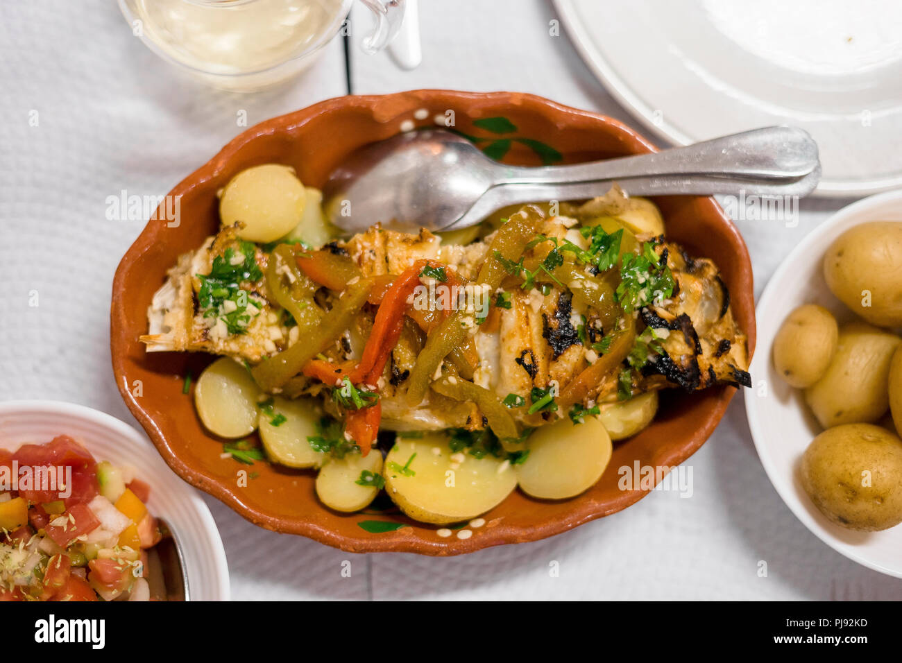 Traditional portuguese golden fish with red and green pepper served ...