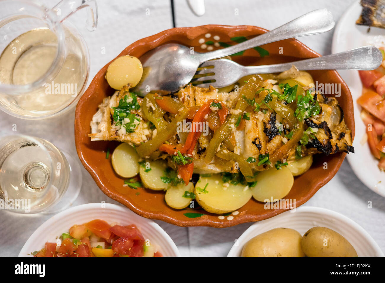Traditional portuguese golden fish with red and green pepper served ...