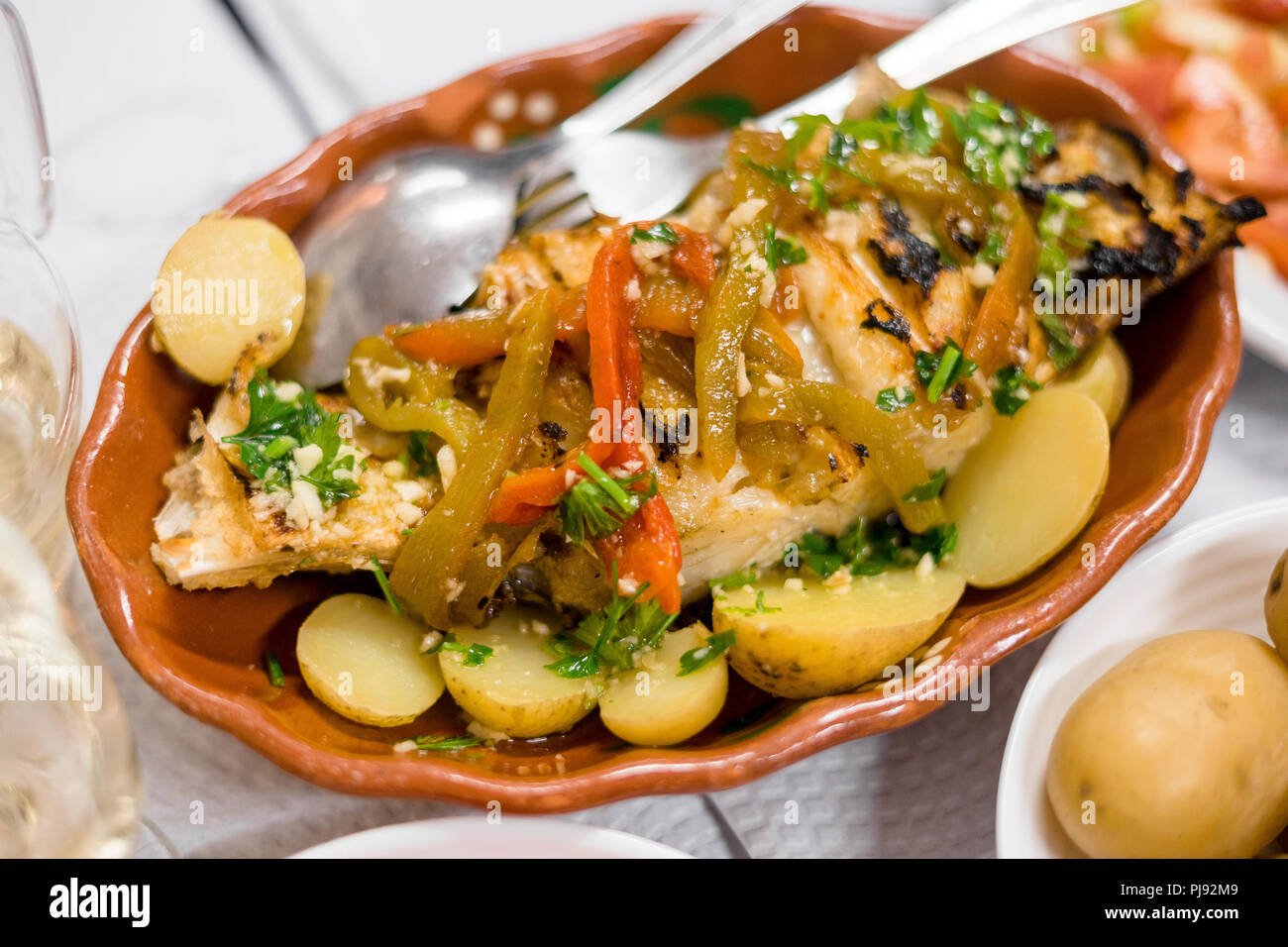 Traditional portuguese golden fish with red and green pepper served ...