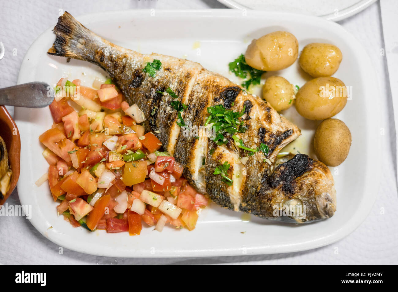 Traditional portuguese grilled golden fish served with potatoes and ...