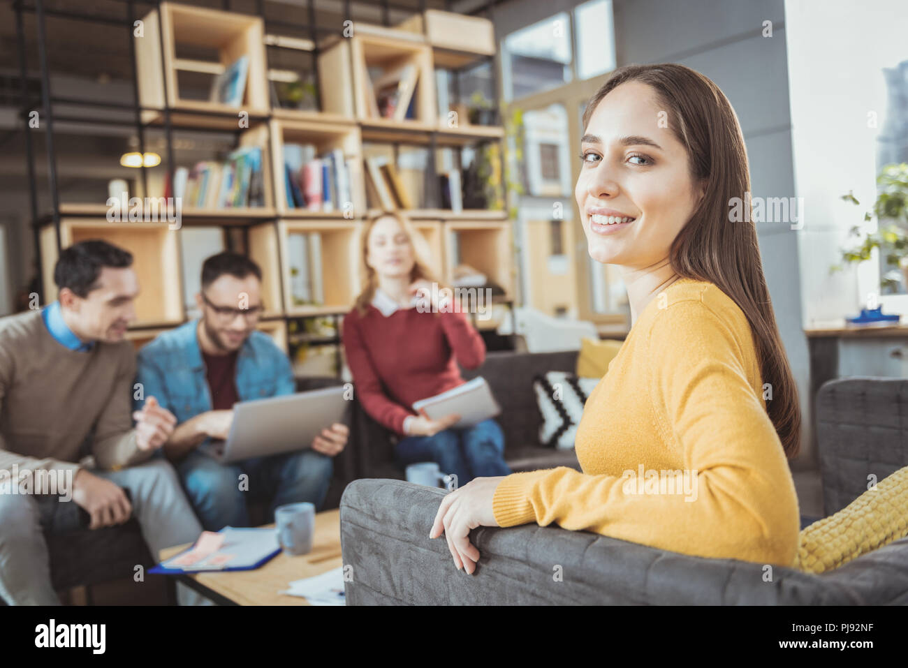 Happy female colleague working in team Stock Photo - Alamy