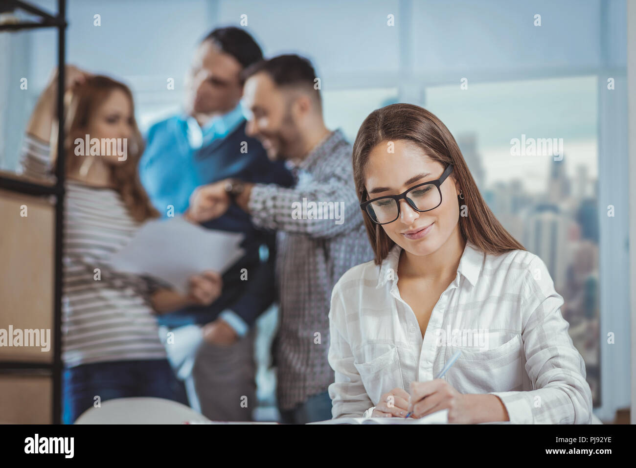 Happy female colleague writing ideas Stock Photo - Alamy