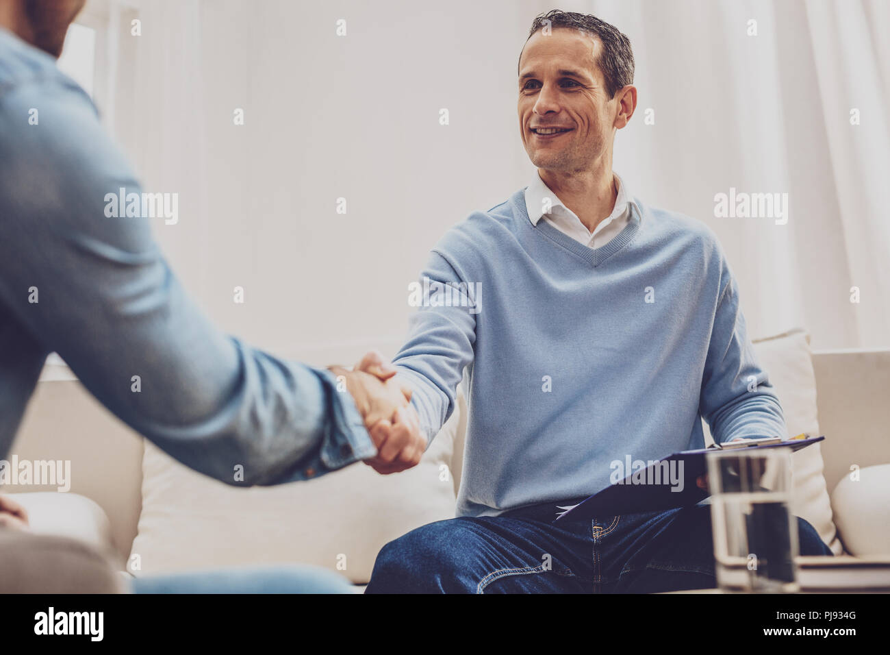 Happy pleasant man giving his hand Stock Photo - Alamy