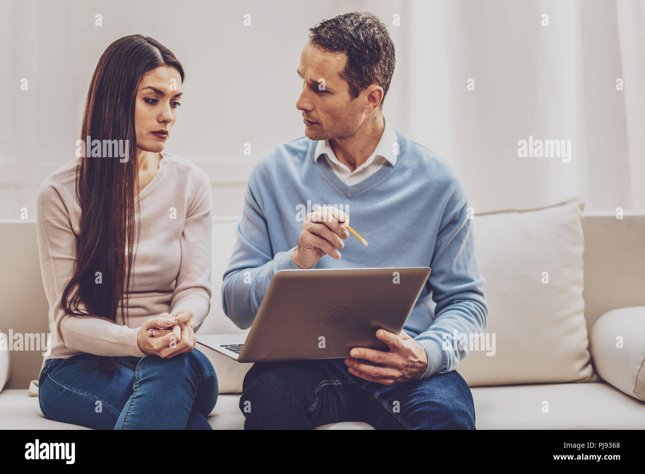 Serious young man pointing at the laptop screen Stock Photo - Alamy