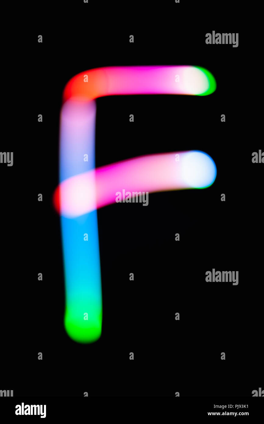 Letter F. Glowing letters on dark background. Abstract light painting ...