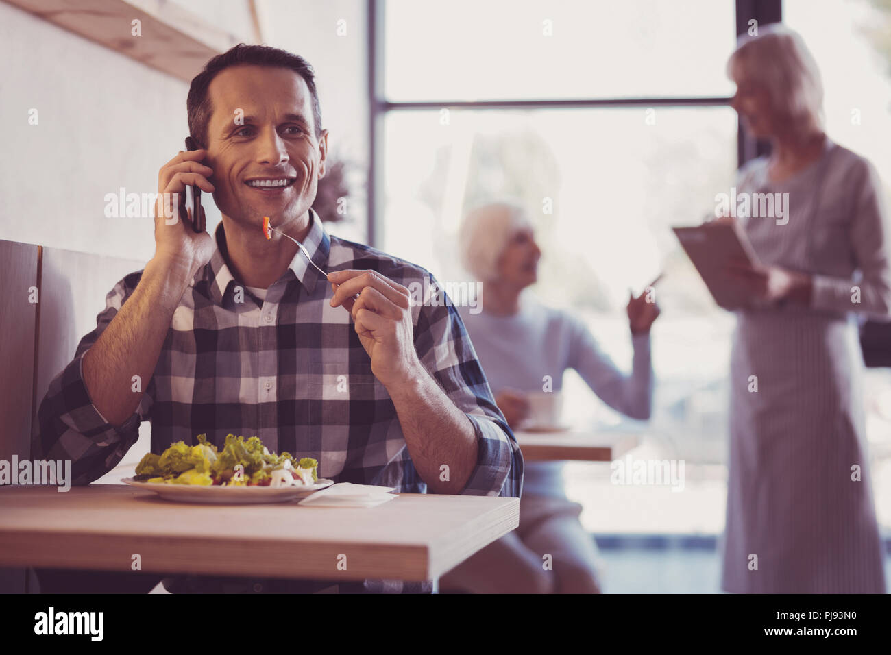 Joyful handsome man eating and communicating Stock Photo - Alamy
