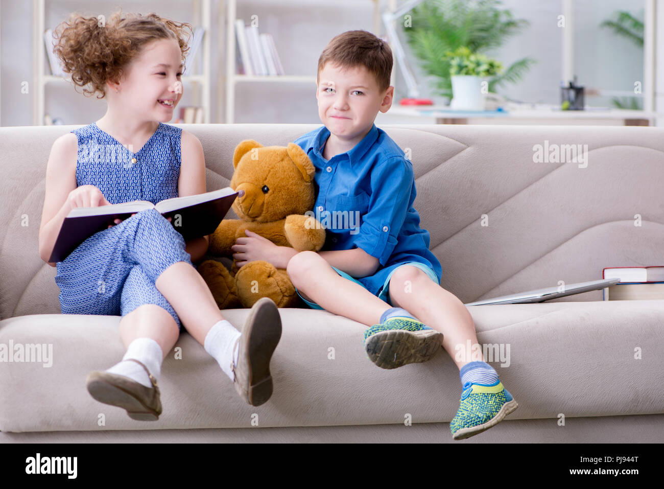 Two kids reading books at home Stock Photo - Alamy