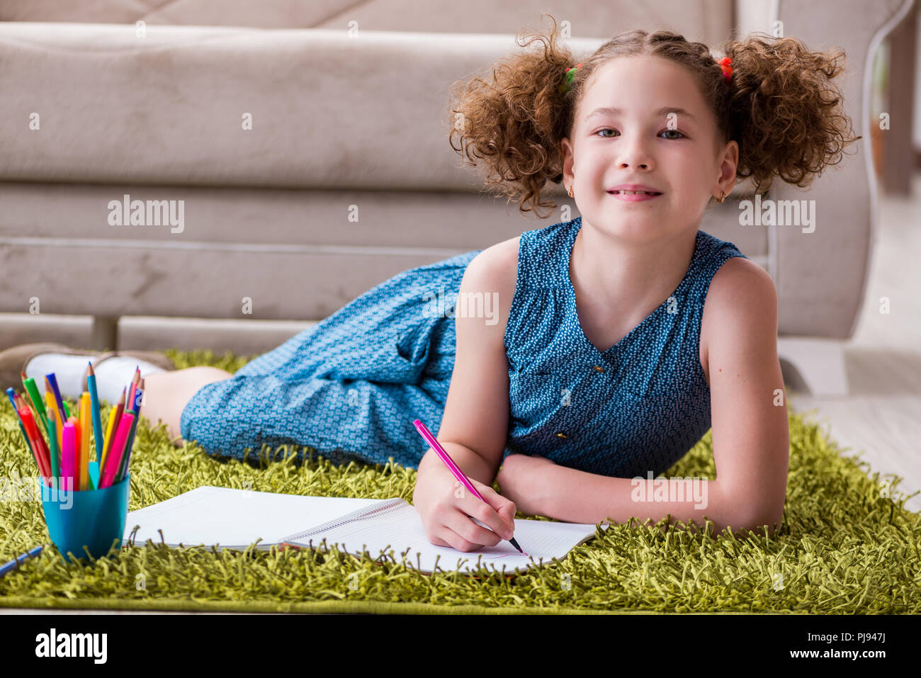 Young little girl drawing on paper with pencils Stock Photo - Alamy
