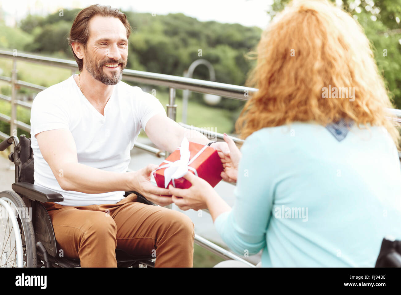 Extremely happy man giving present to his soulmate Stock Photo - Alamy