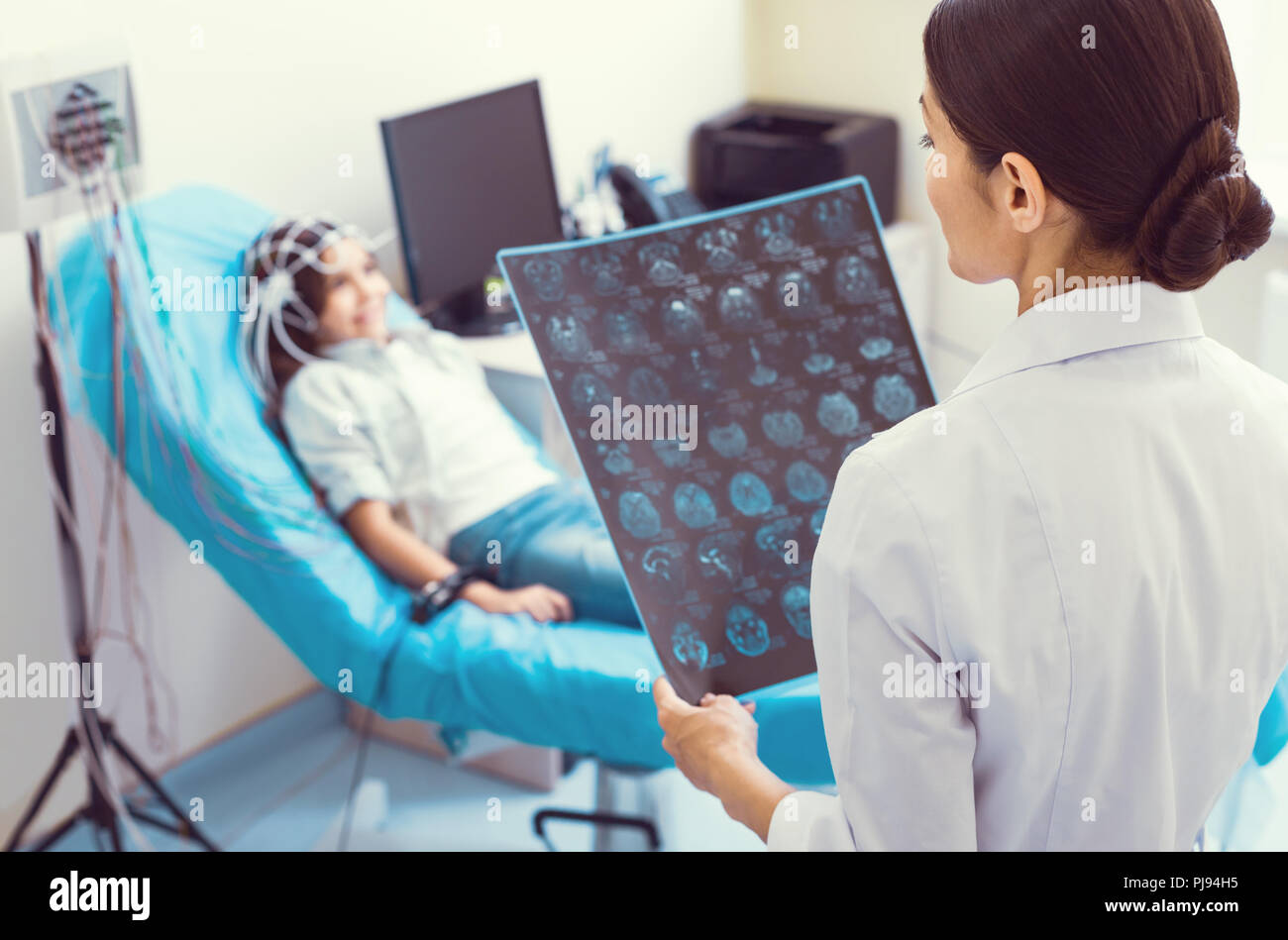 Young radiologist analyzing computed tomography scan of little girl ...