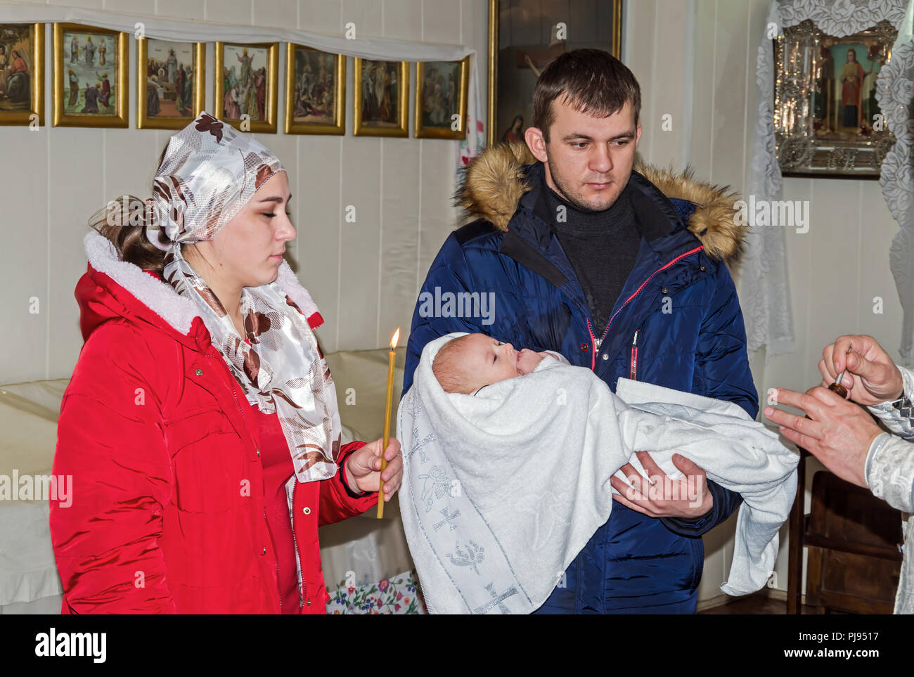 Godfather and godmother are keep in arms of child during the rite of ...