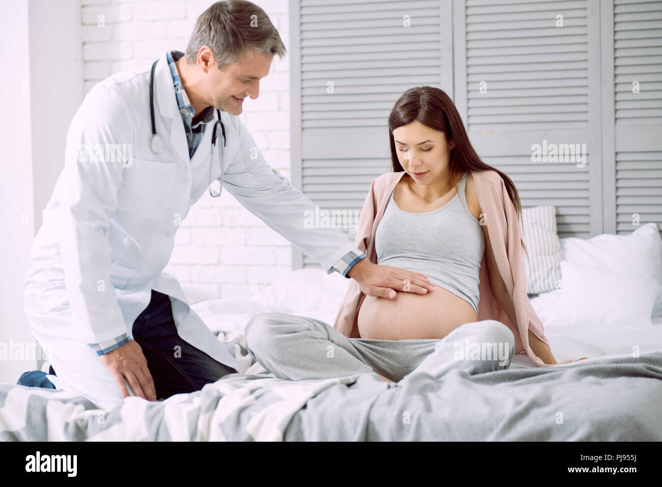 Nice friendly doctor checking his patient Stock Photo - Alamy
