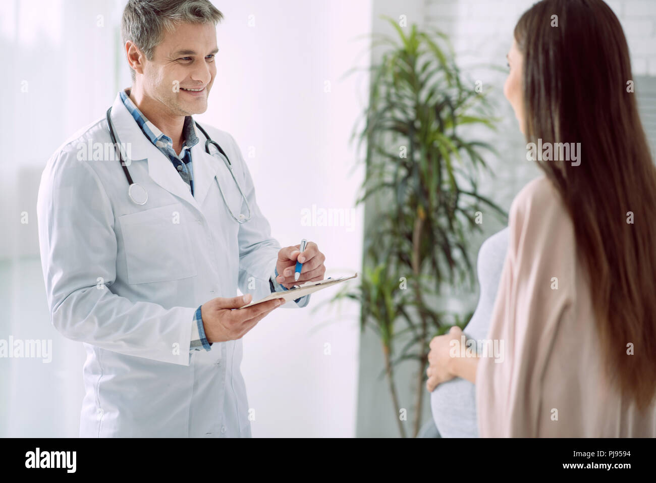 Delighted positive doctor writing a conclusion Stock Photo - Alamy