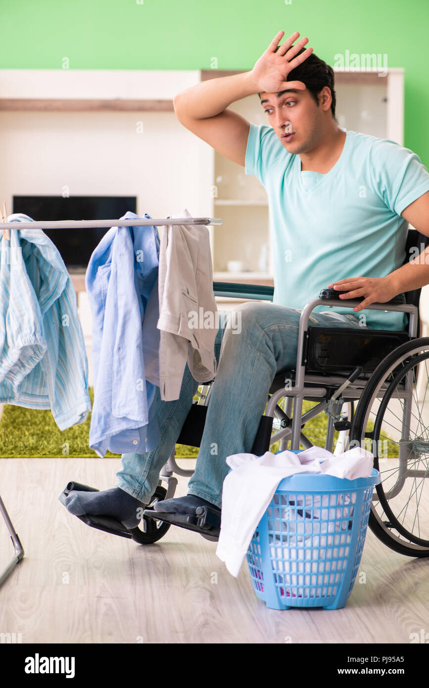 Disabled man on wheelchair doing laundry Stock Photo - Alamy