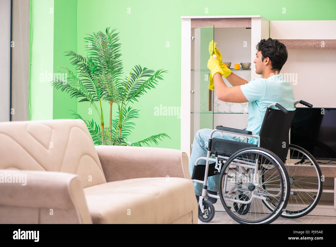 Disabled man on wheelchair cleaning house Stock Photo - Alamy