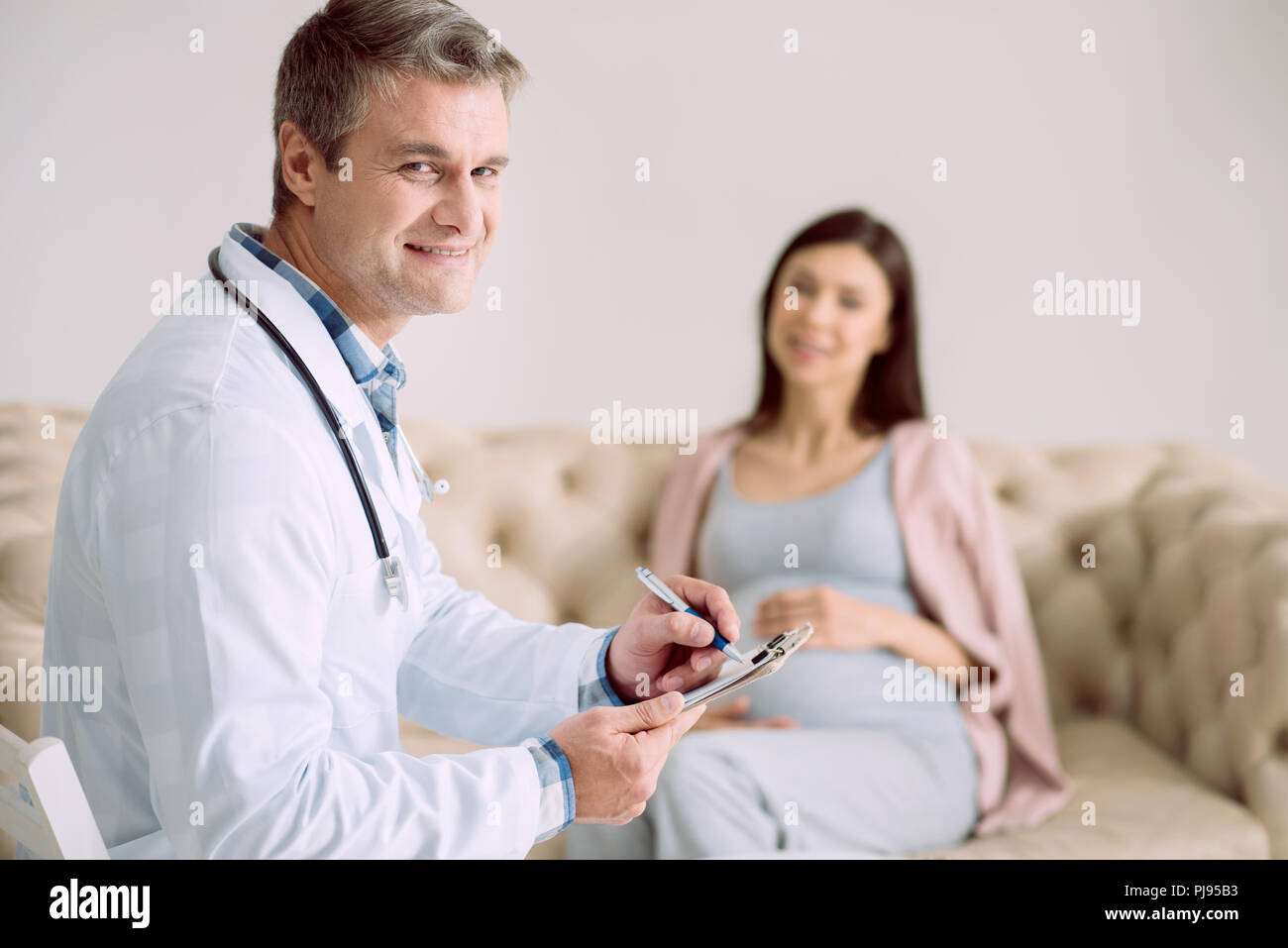 Delighted smart doctor smiling Stock Photo - Alamy