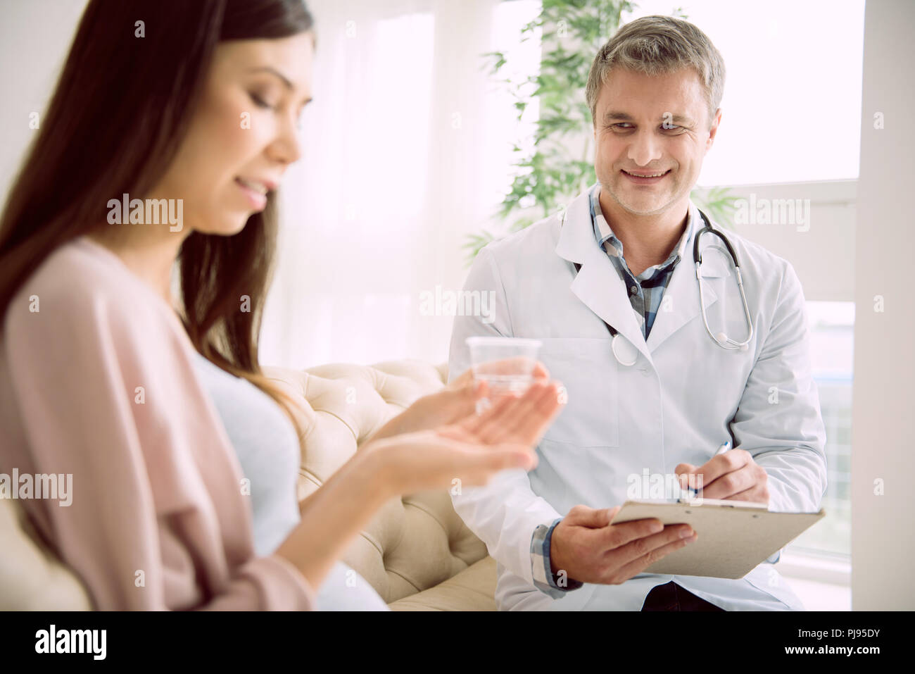 Delighted skillful doctor observing her patient Stock Photo - Alamy