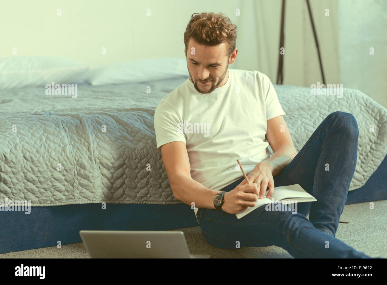 Smart young gentleman taking notes while studying at home Stock Photo ...