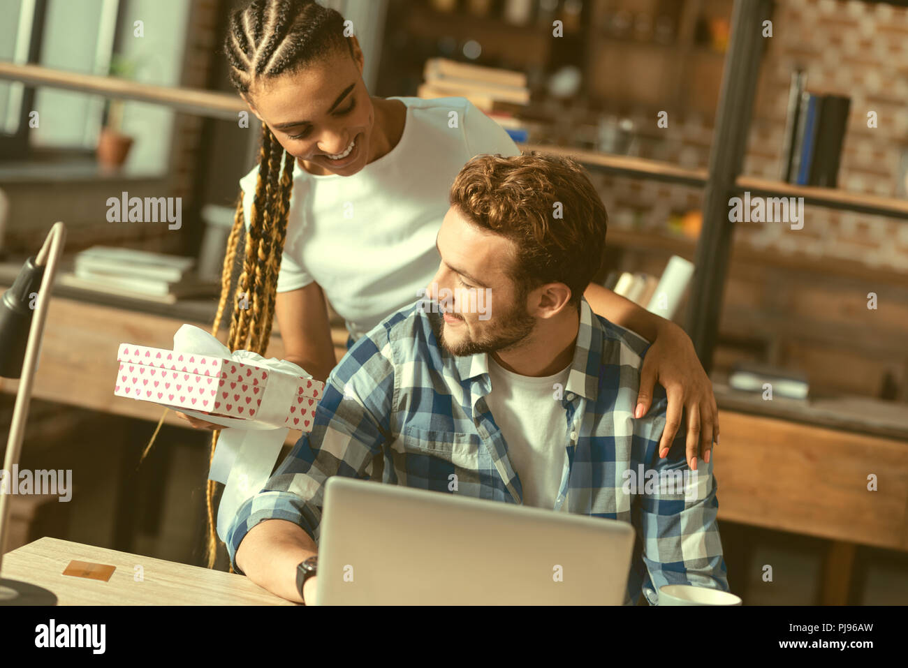Mindful girl giving her boyfriend beautifully wrapped present Stock ...