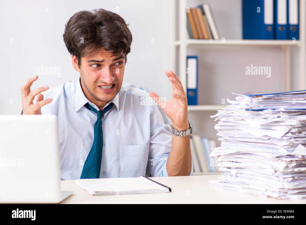 Overloaded busy employee with too much work and paperwork Stock Photo ...
