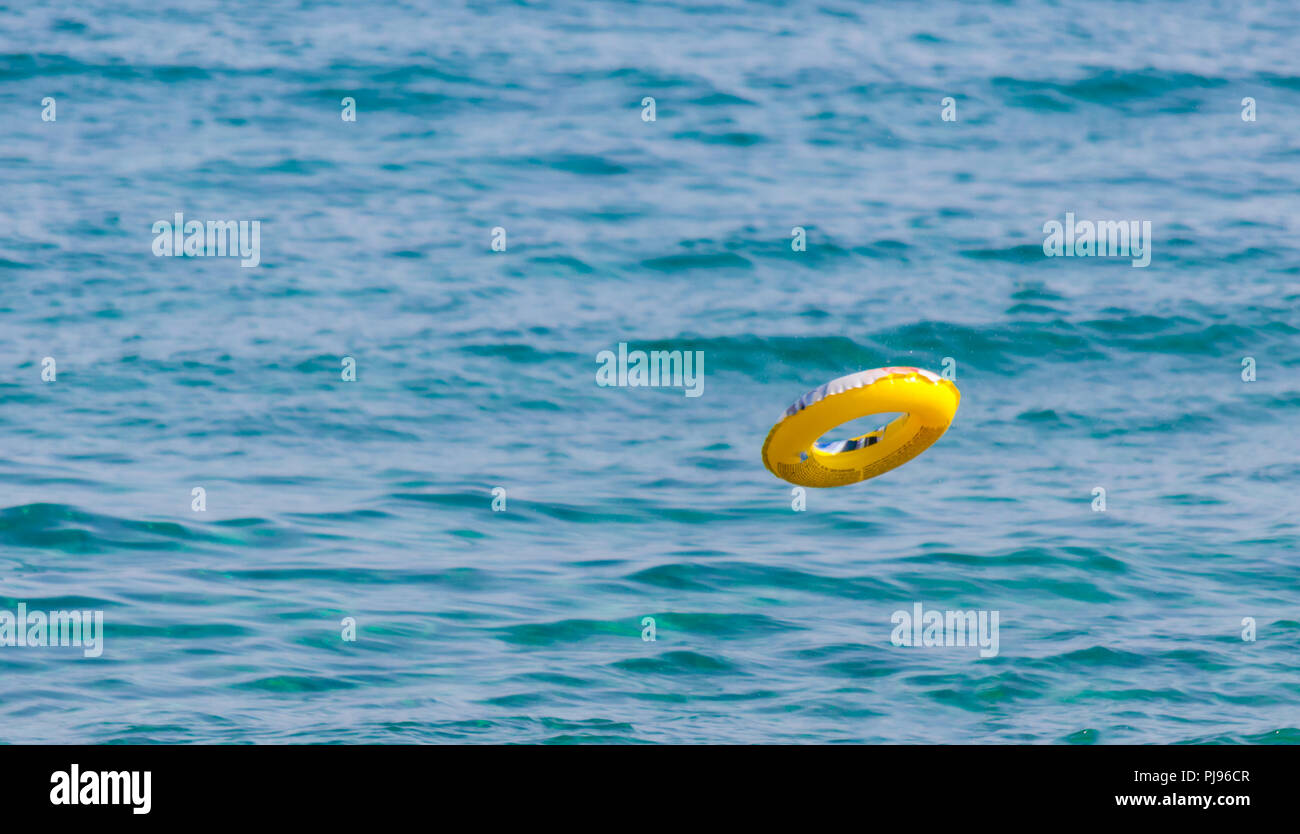yellow life buoy flying on the sea Stock Photo - Alamy
