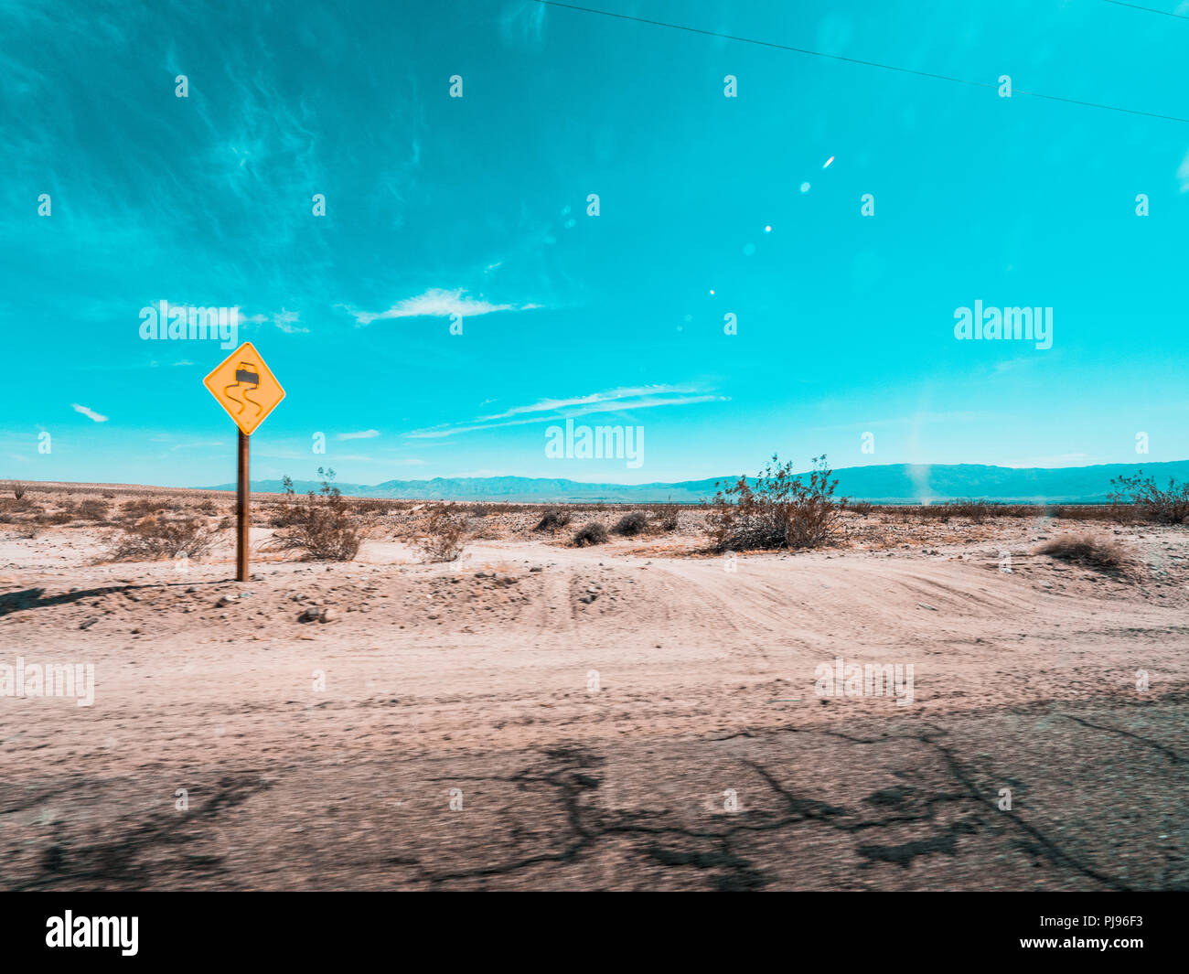Desert roads and vegetation with dead tree and road sign Stock Photo ...