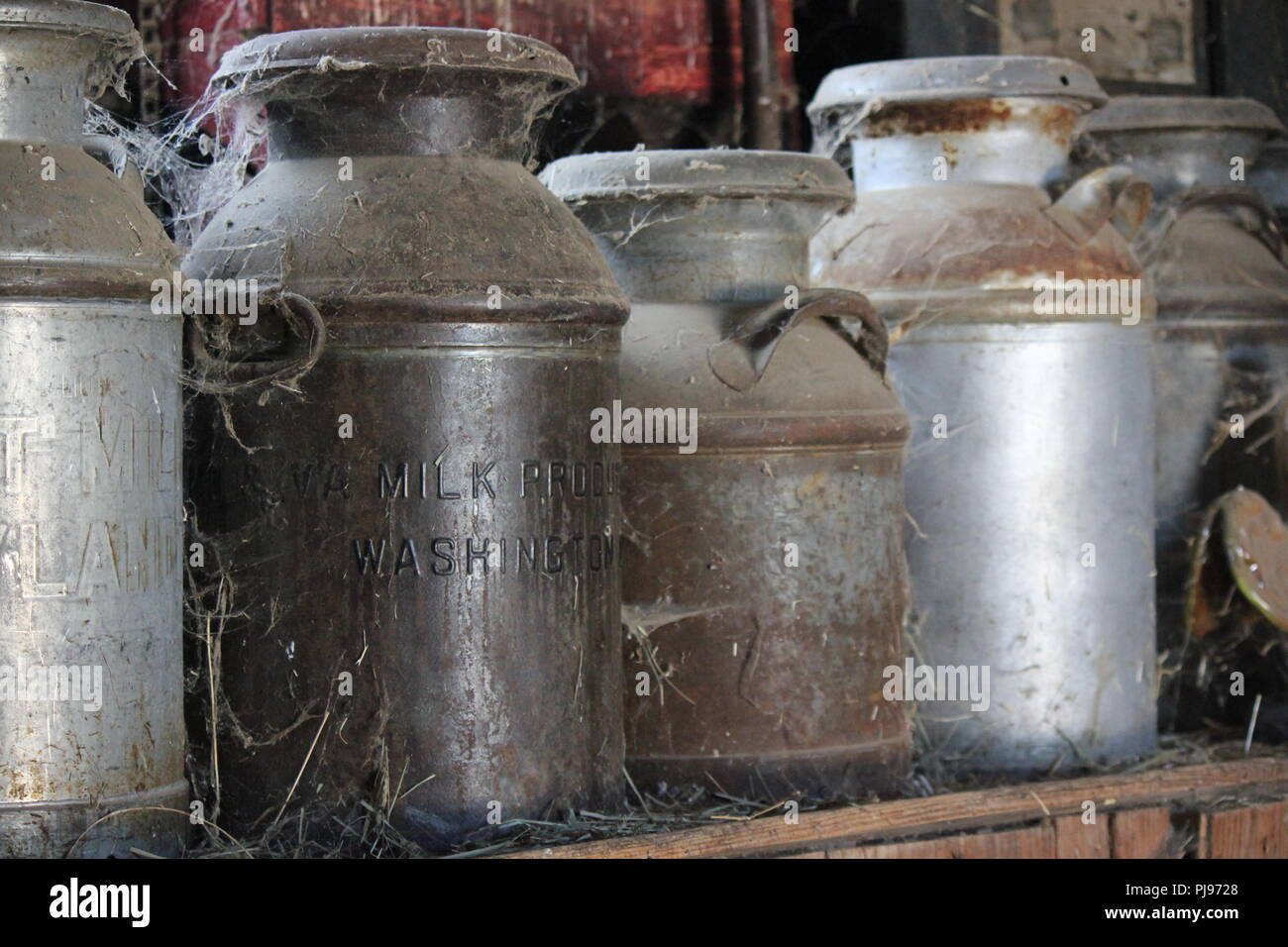 Old fashioned milk jugs stored in the barn on a hot summer day Stock ...